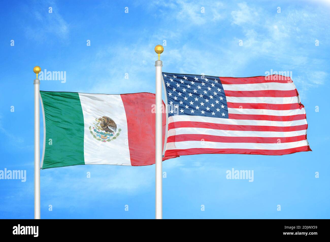 Mexico and United States two flags on flagpoles and blue cloudy sky ...