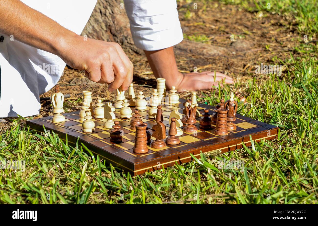 A closeup shot of a man playing chess, moving the bishop on the ...