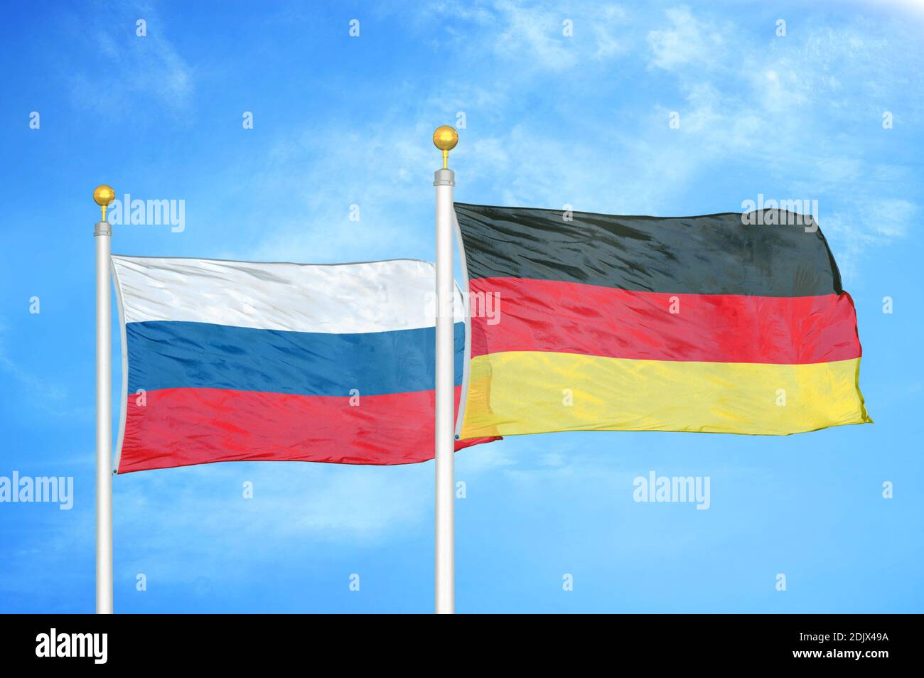 Russia and Germany two flags on flagpoles and blue cloudy sky Stock ...