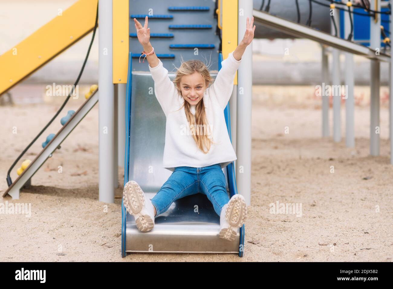 Portrait Of Girl Sliding In Playground Stock Photo - Alamy