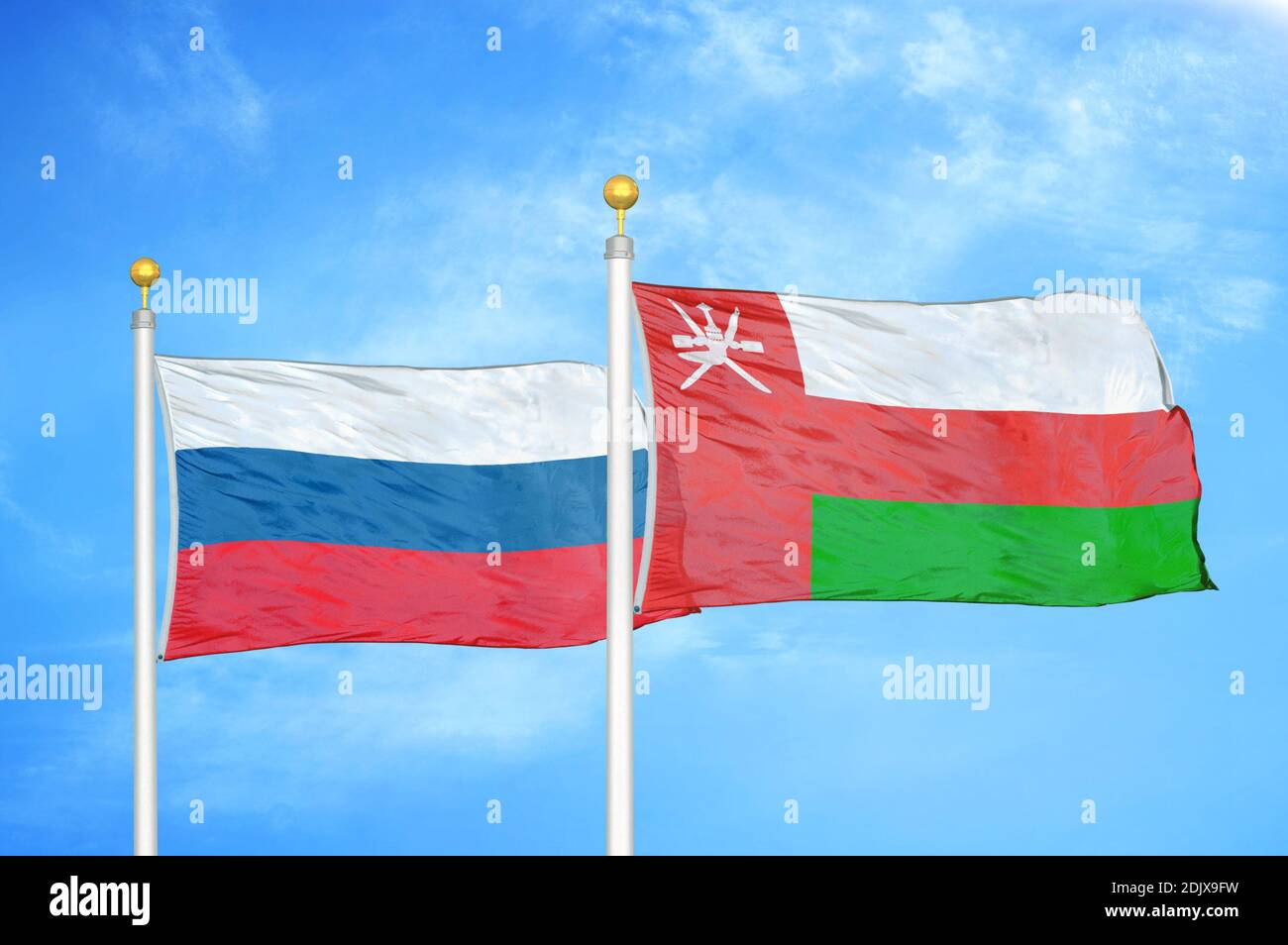 Russia and Oman two flags on flagpoles and blue cloudy sky Stock Photo ...