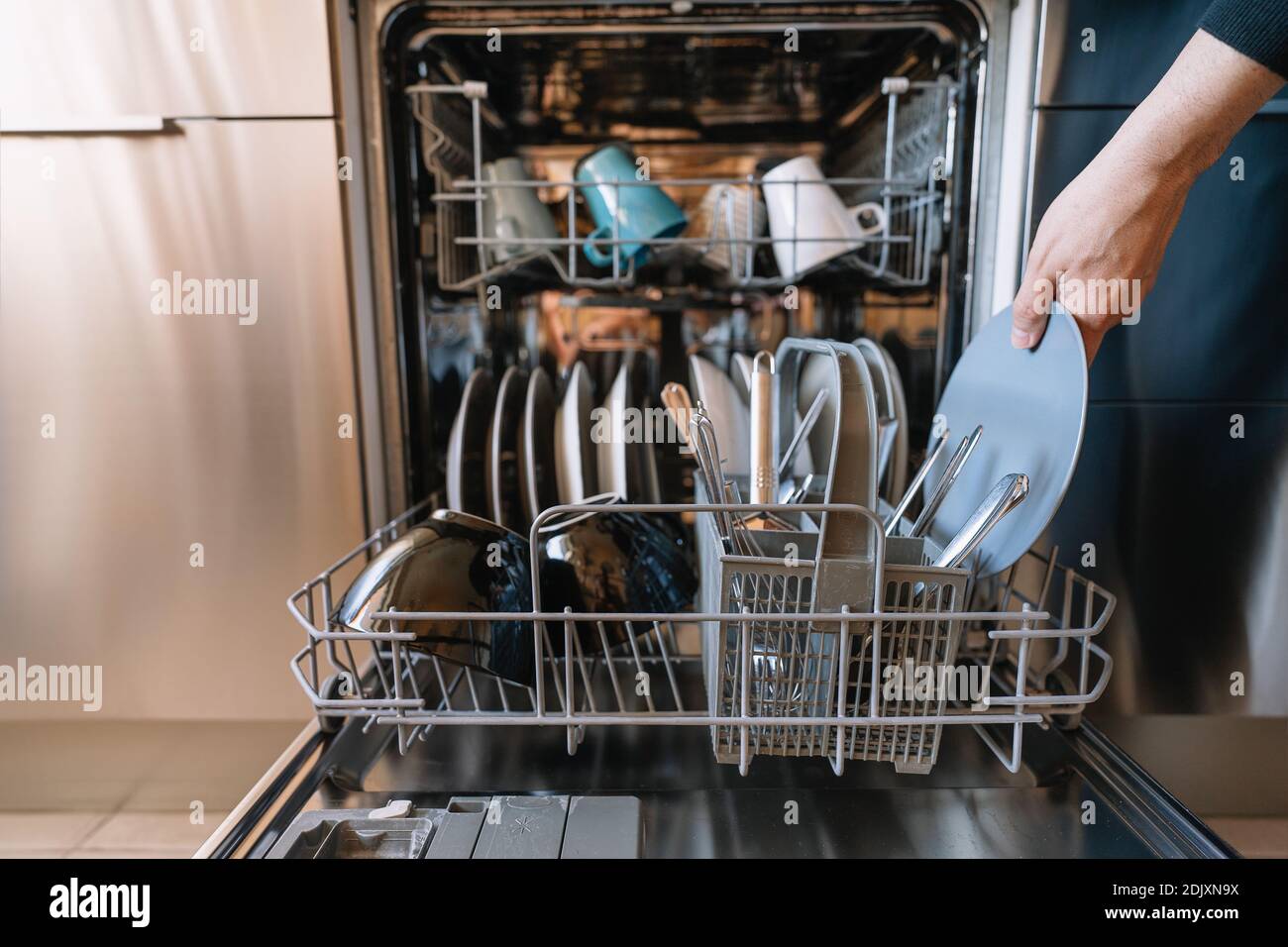 Man loading dishwasher hi-res stock photography and images - Alamy