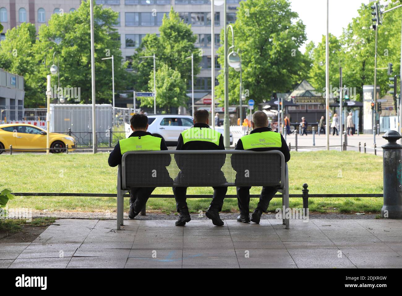 Germany, Berlin, three men sitting on a bench, back view Stock Photo ...