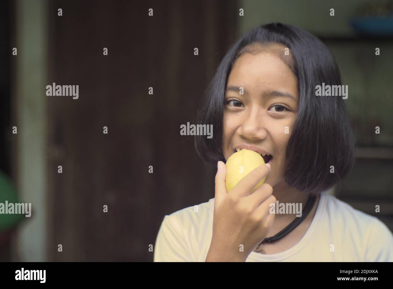 Portrait Of Girl Eating Fruit Stock Photo - Alamy