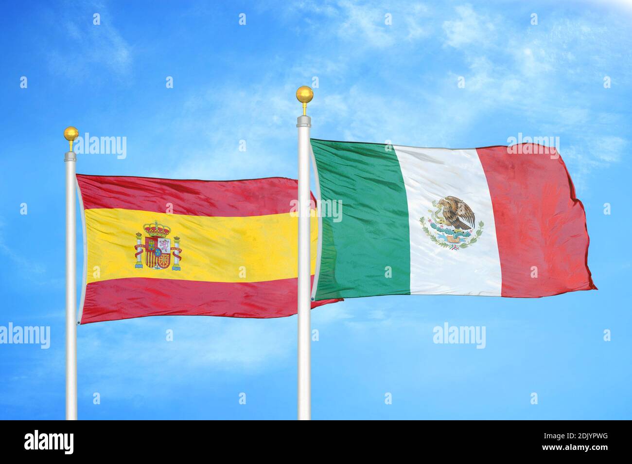 Spain and Mexico two flags on flagpoles and blue cloudy sky Stock Photo ...