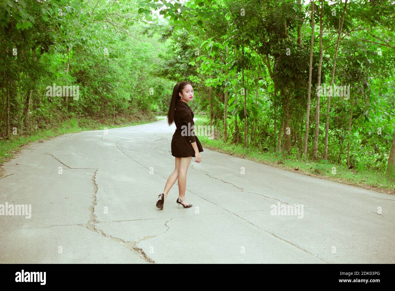 Side View Of Woman Walking On Road Along Trees Stock Photo - Alamy
