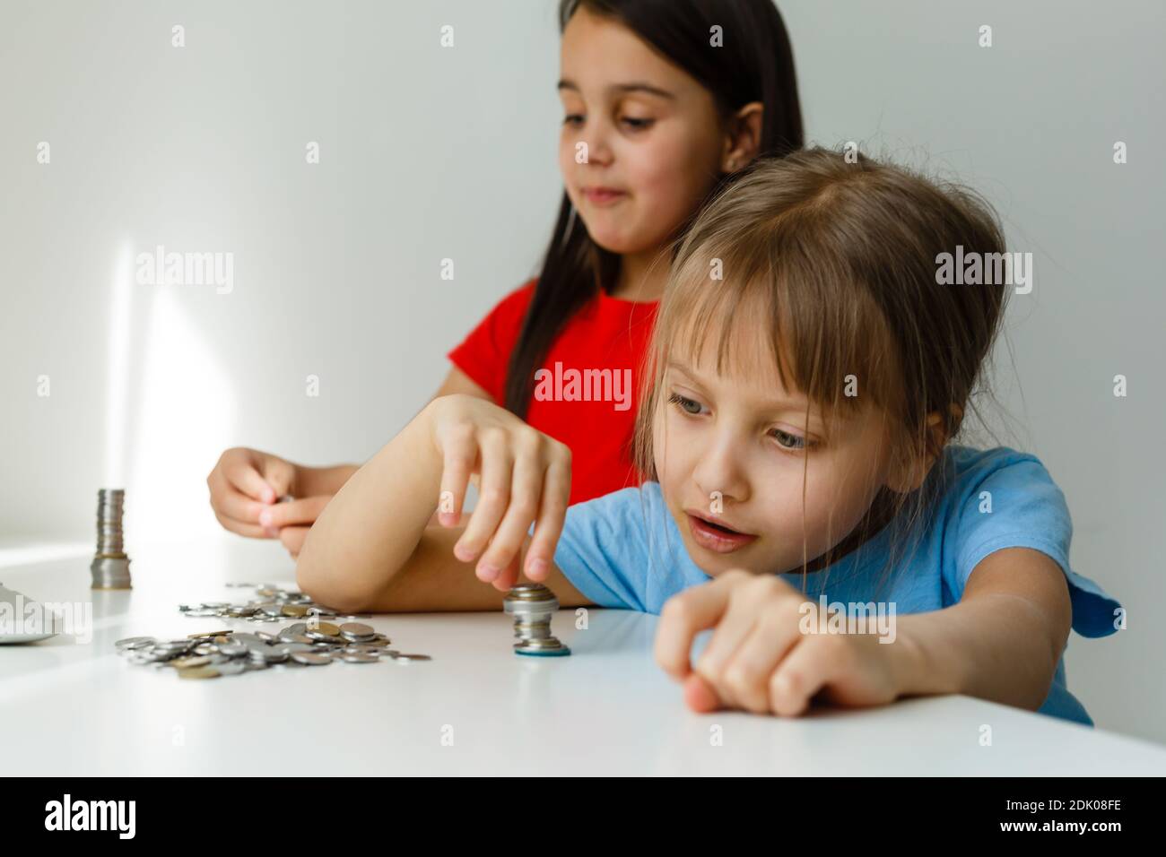 Two kids counting coins together Stock Photo - Alamy