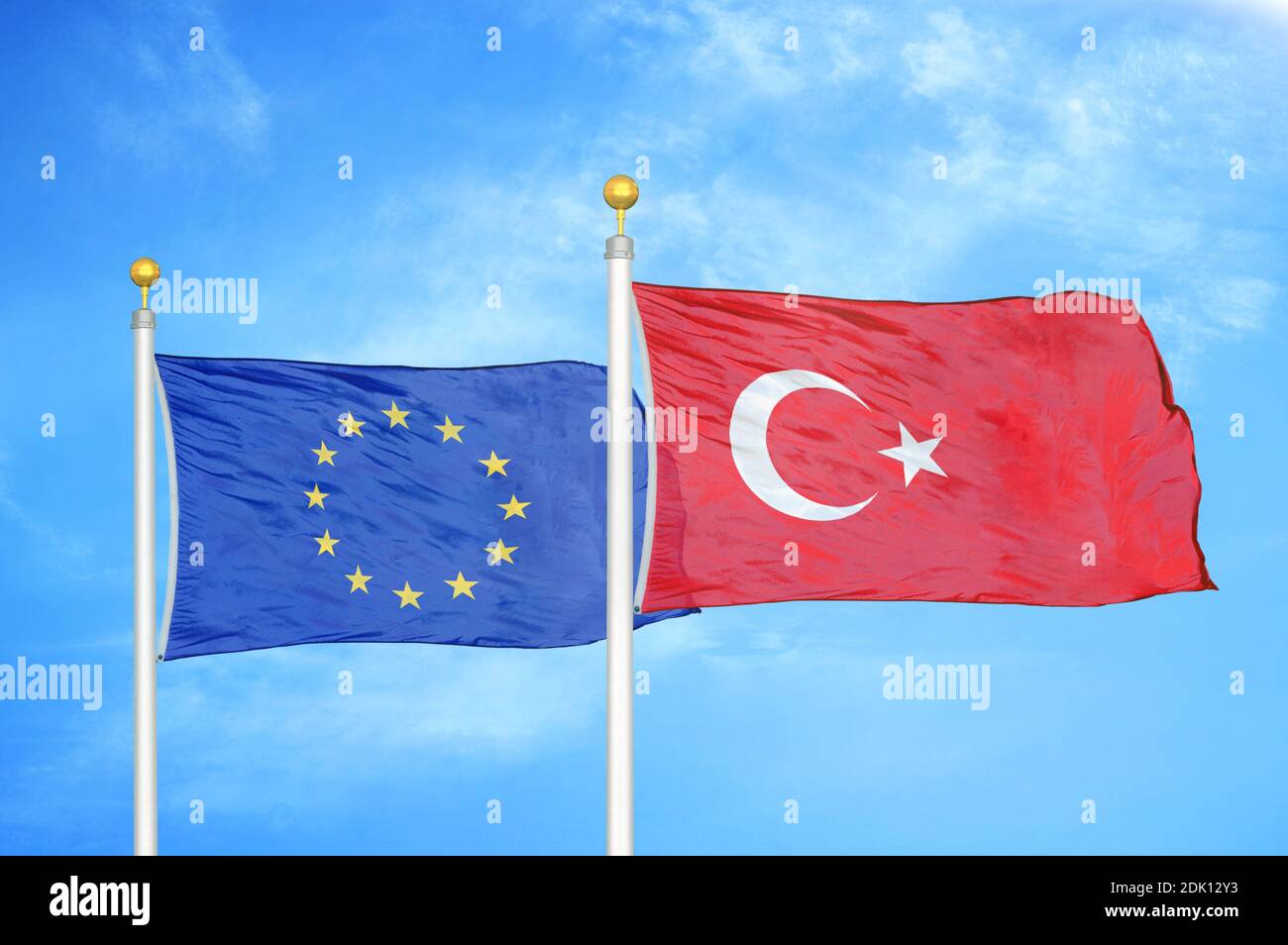 European Union and Turkey two flags on flagpoles and blue cloudy sky ...