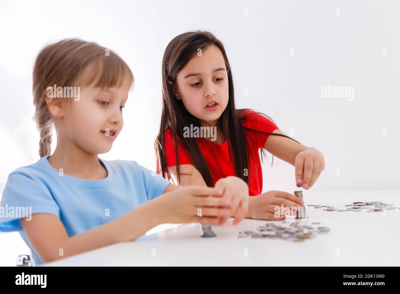 Two kids counting coins together Stock Photo - Alamy