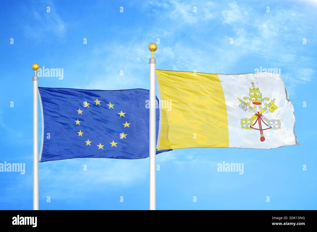 European Union and Vatican two flags on flagpoles and blue cloudy sky ...
