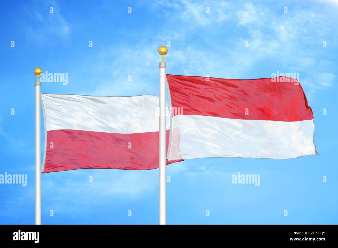 Poland and Indonesia two flags on flagpoles and blue cloudy sky Stock ...