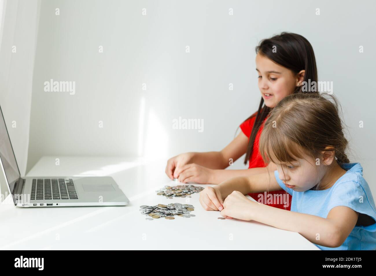 Two kids counting coins together Stock Photo - Alamy