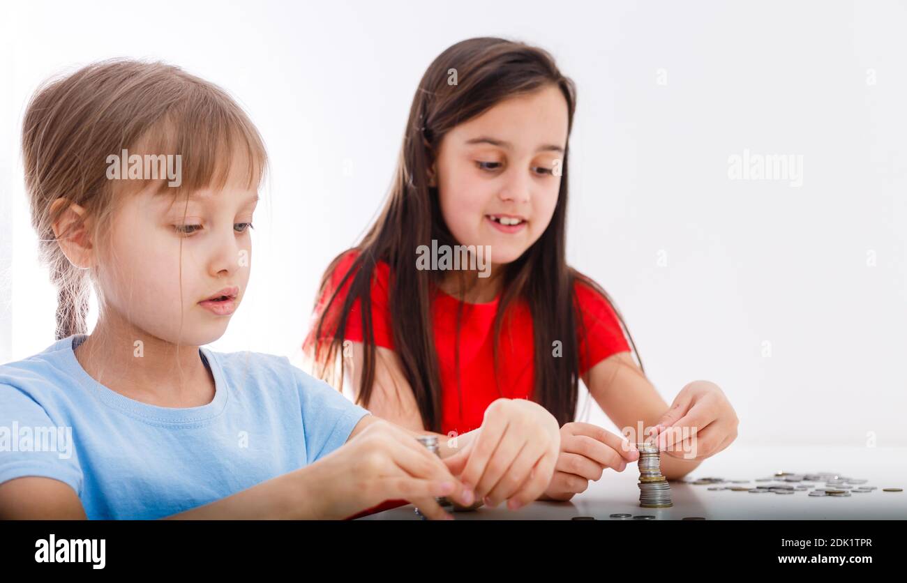 Two kids counting coins together Stock Photo - Alamy