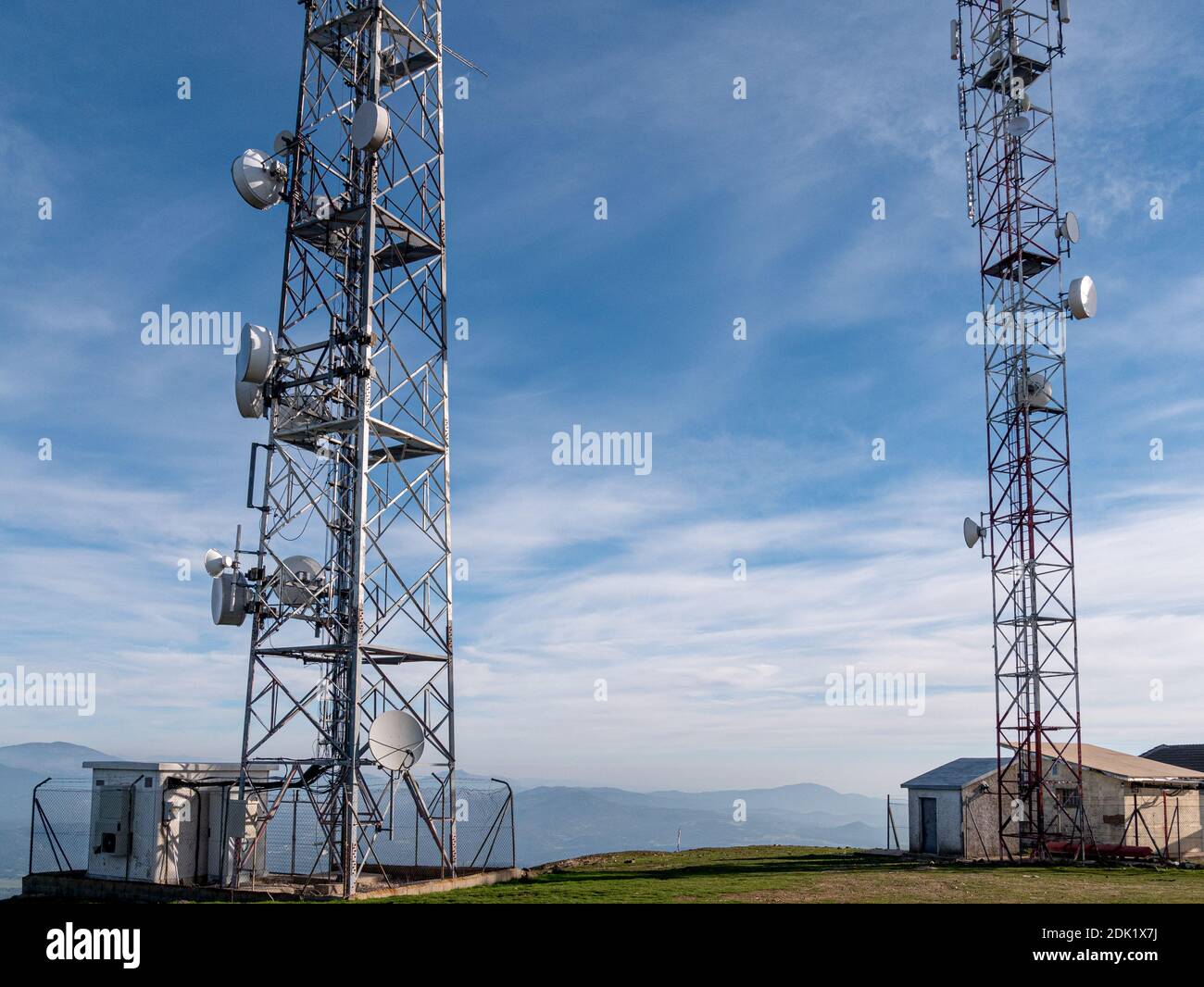 A cloudy sky behind telecommunication wireless towers with antennas ...