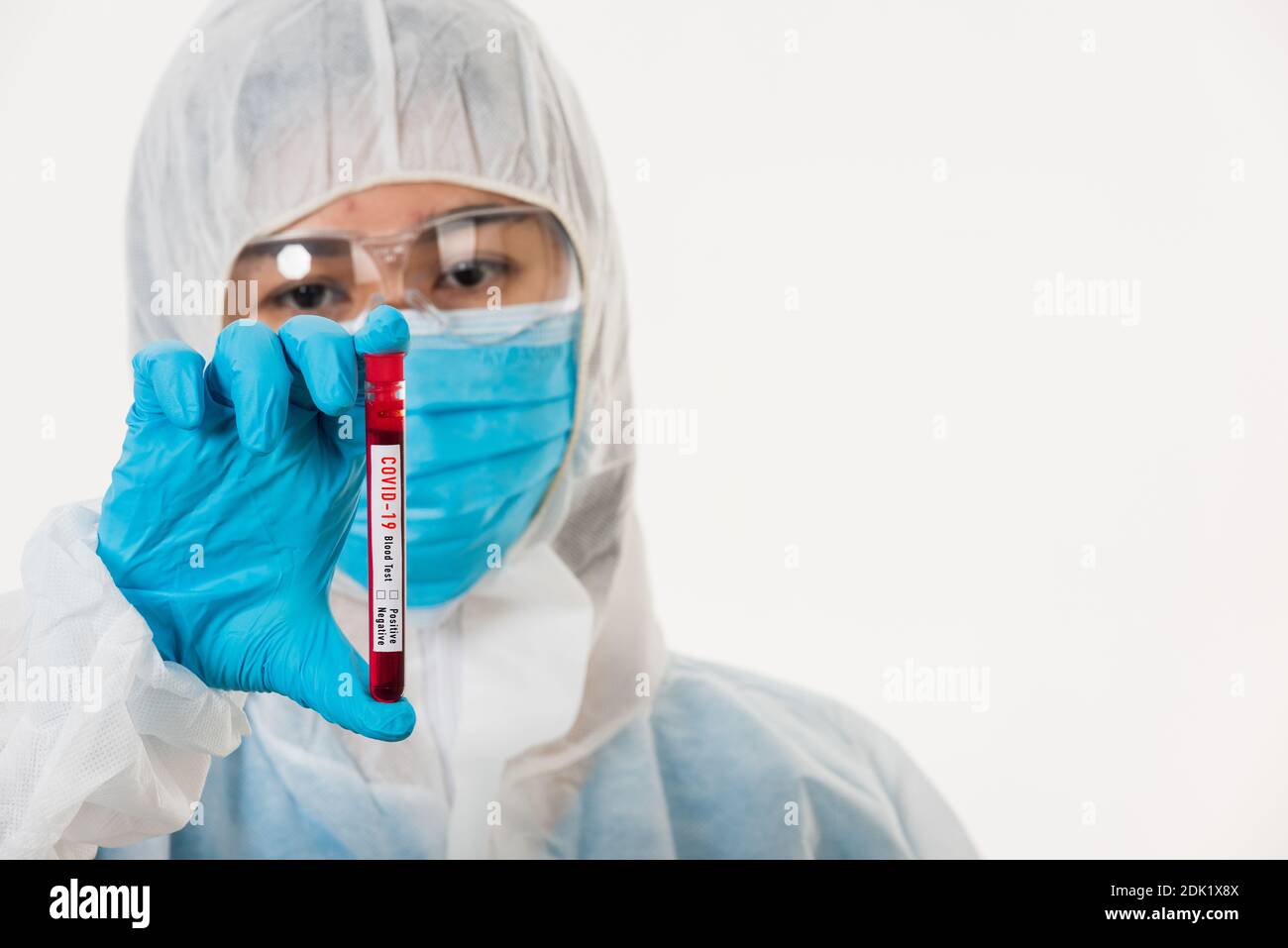 Medical scientist in PPE uniform wear a mask holding test tube ...