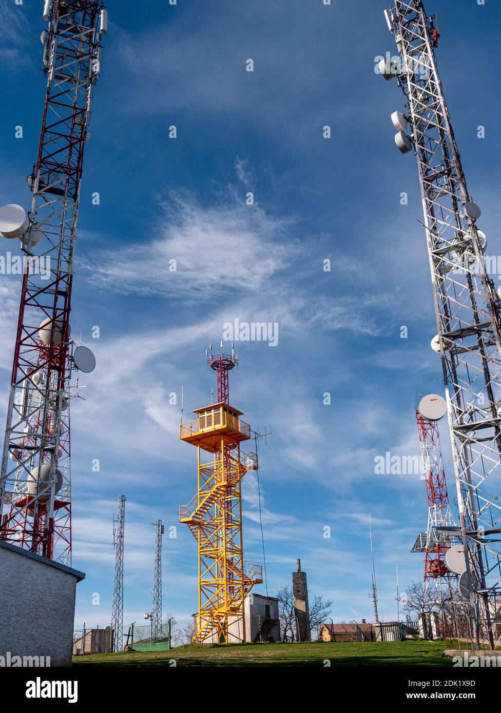 A vertical shot of a cloudy sky behind telecommunication wireless ...