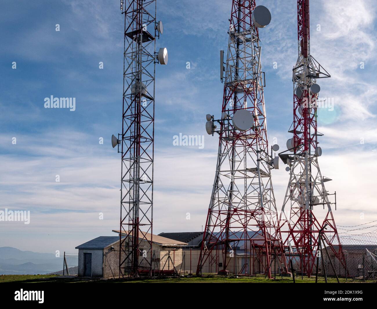 A cloudy sky behind telecommunication wireless towers with antennas ...