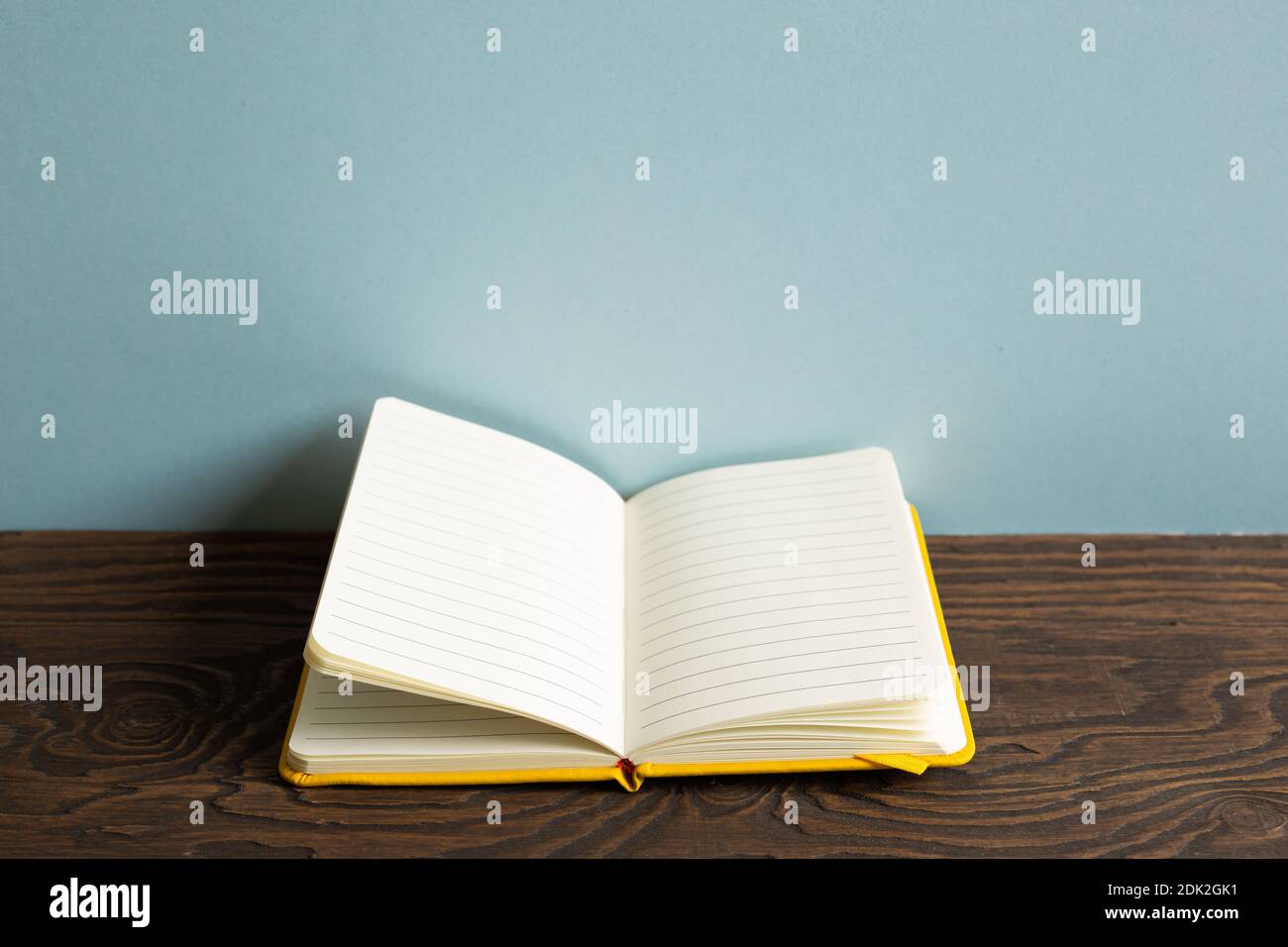 Open note book on wooden desk. sky blue background Stock Photo - Alamy