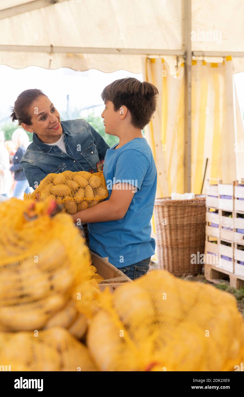 Mother and son buy potatoes at the weekly market Stock Photo - Alamy