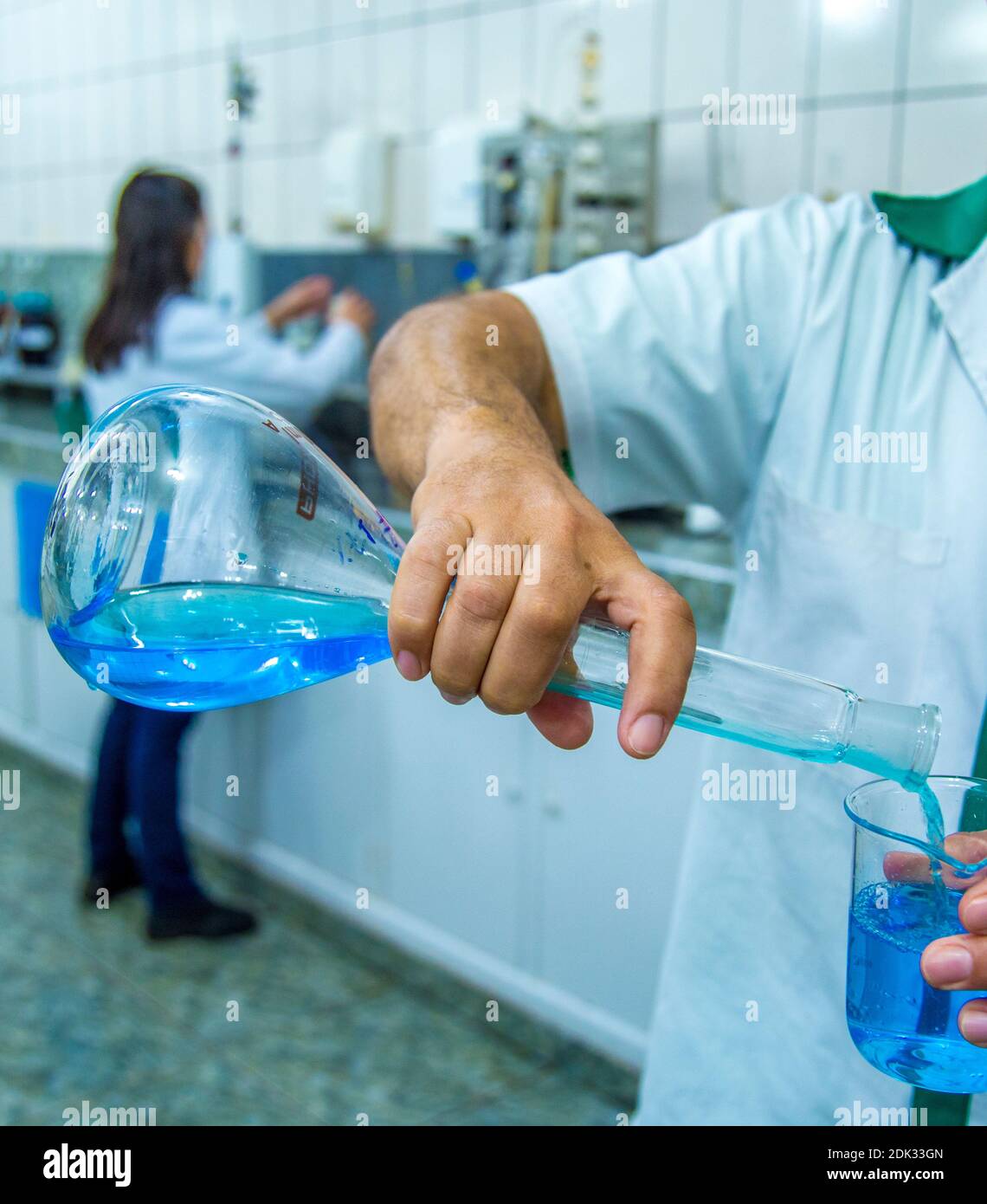Scientist pouring liquid into beaker hi-res stock photography and ...