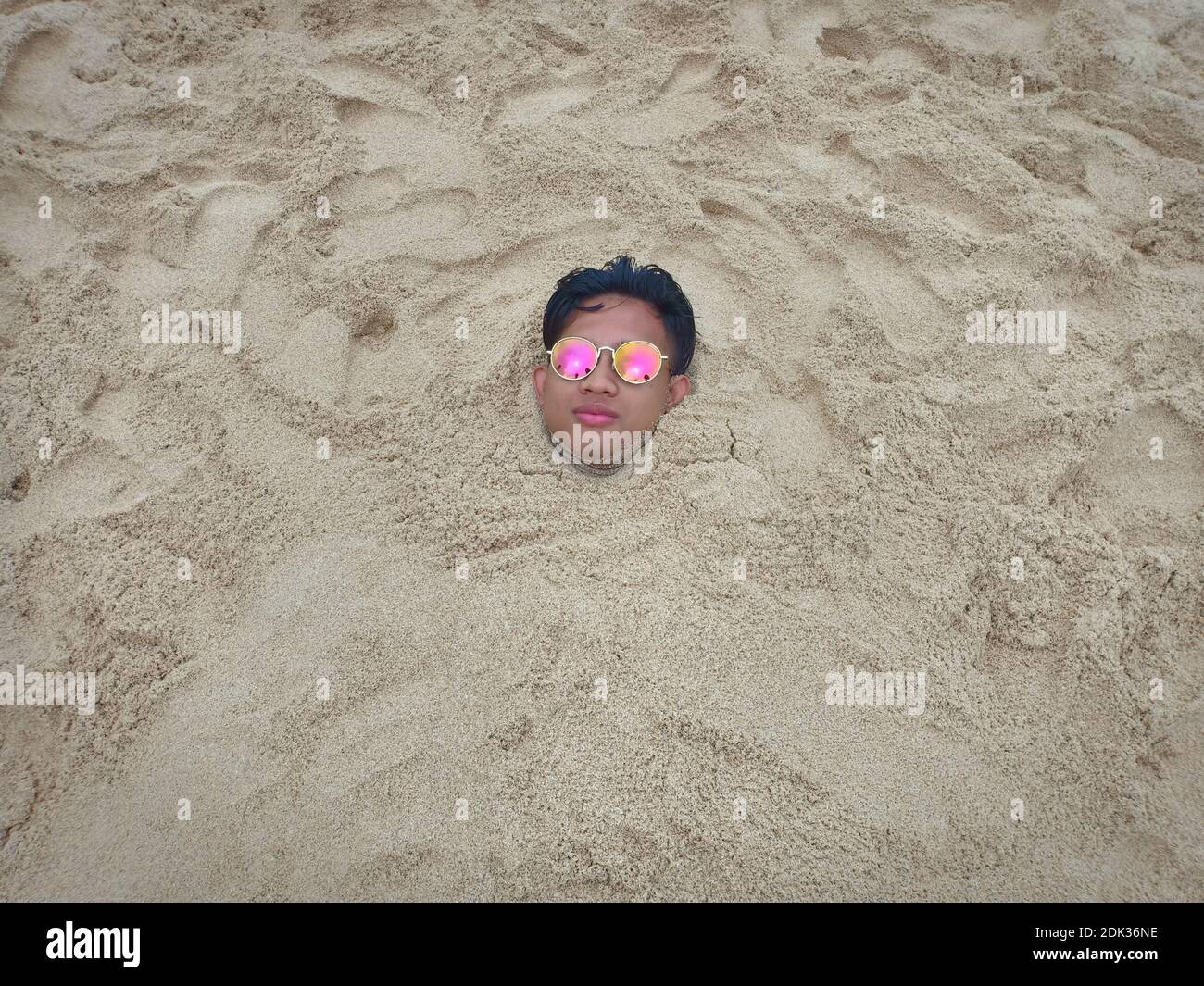 Man buried in the sand hi-res stock photography and images - Alamy