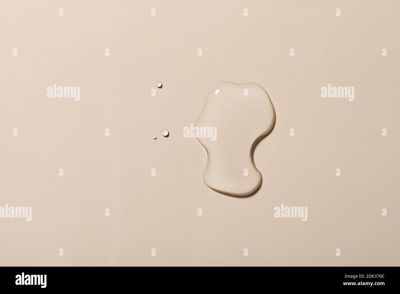 A top vie closeup of multiple waterdrops on a light pink background ...
