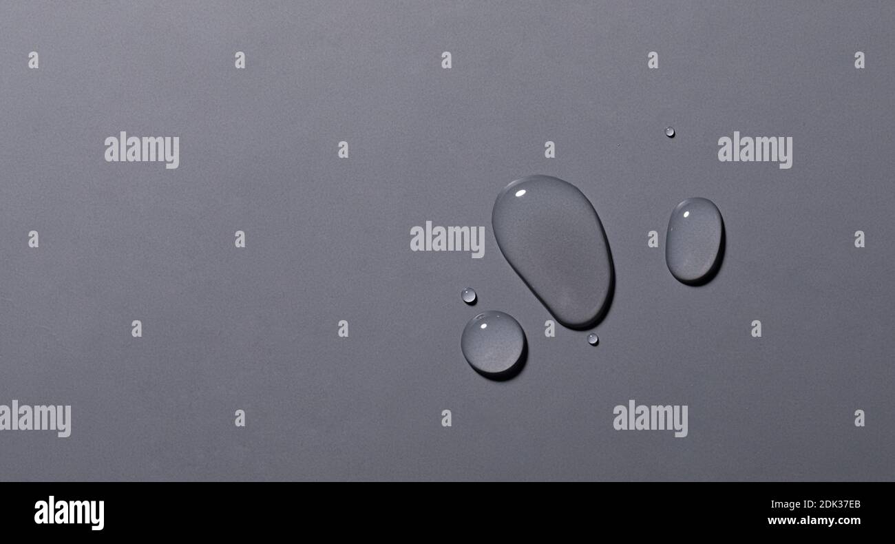 A top view closeup of multiple water drops on a grey background Stock ...