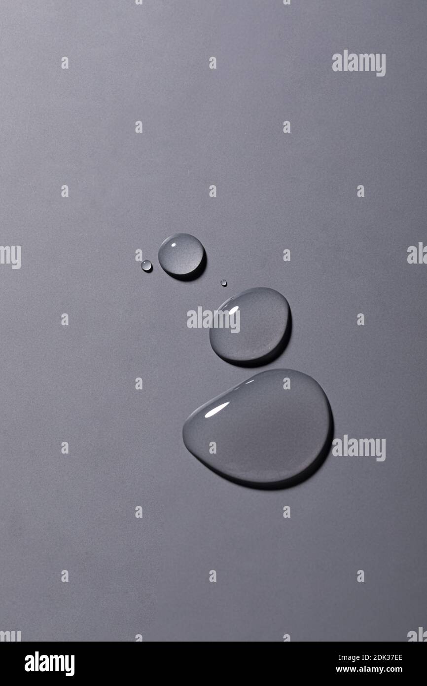 A top view closeup of multiple water drops on a grey background Stock ...