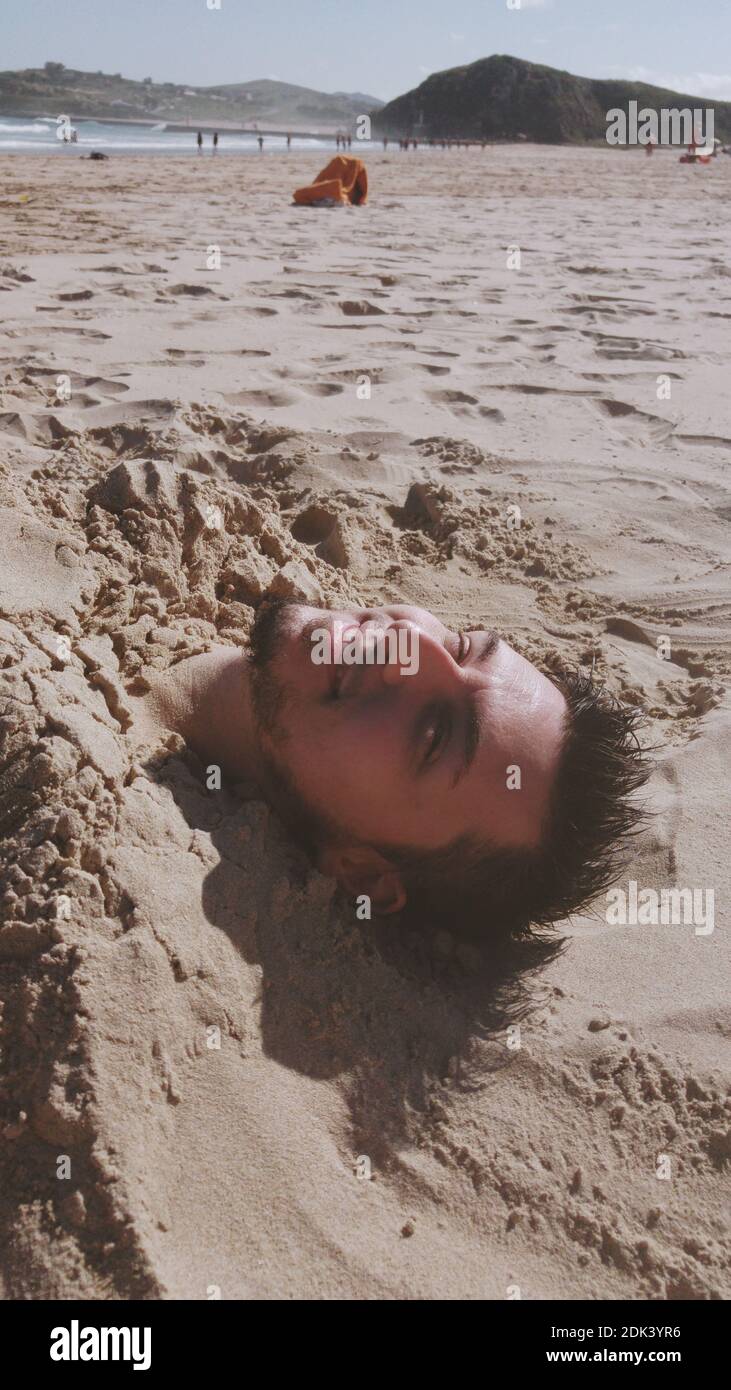 Man buried in the sand hi-res stock photography and images - Alamy