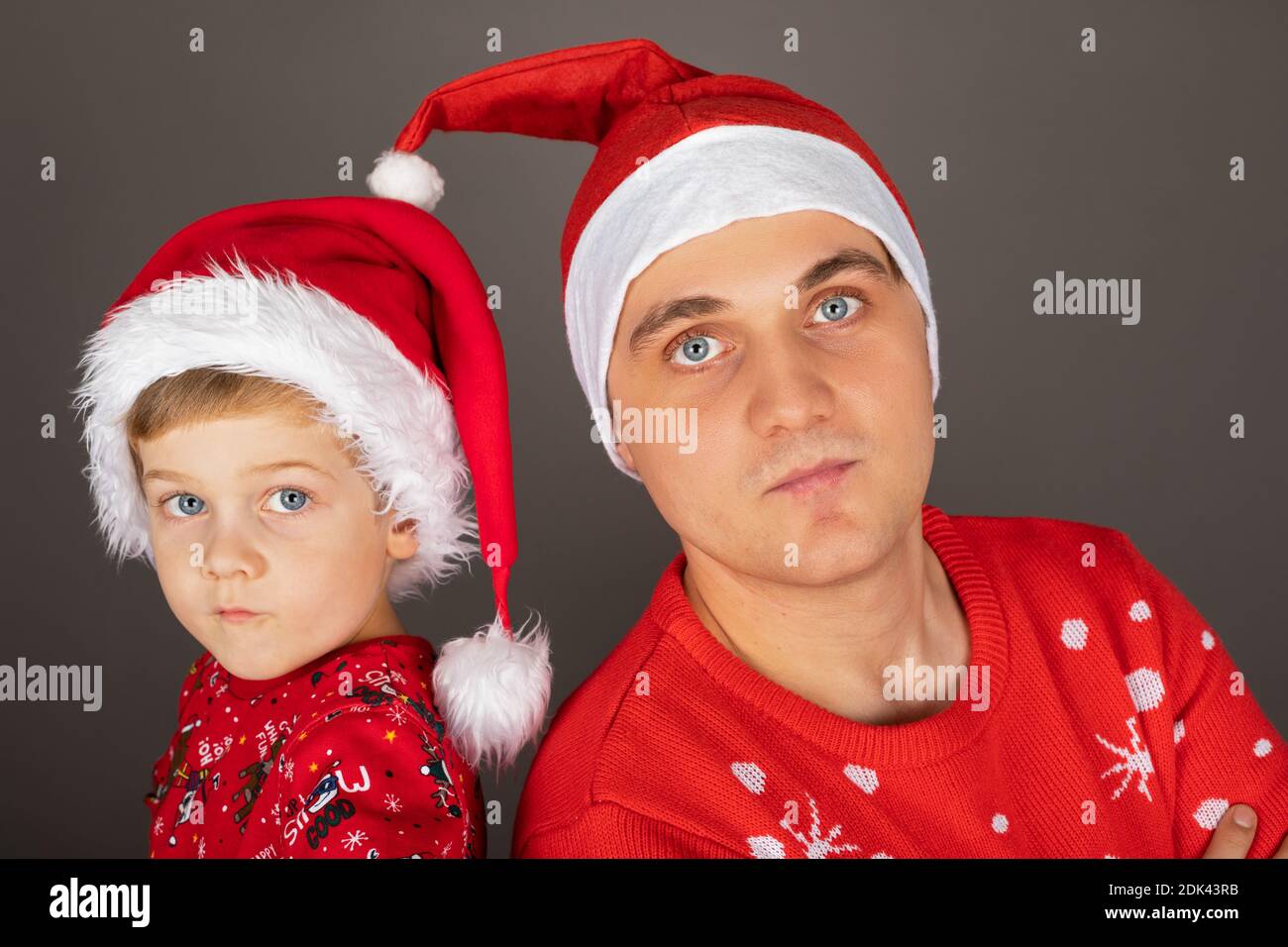 Handsome young father posing with his son, both wearing Christmas ...