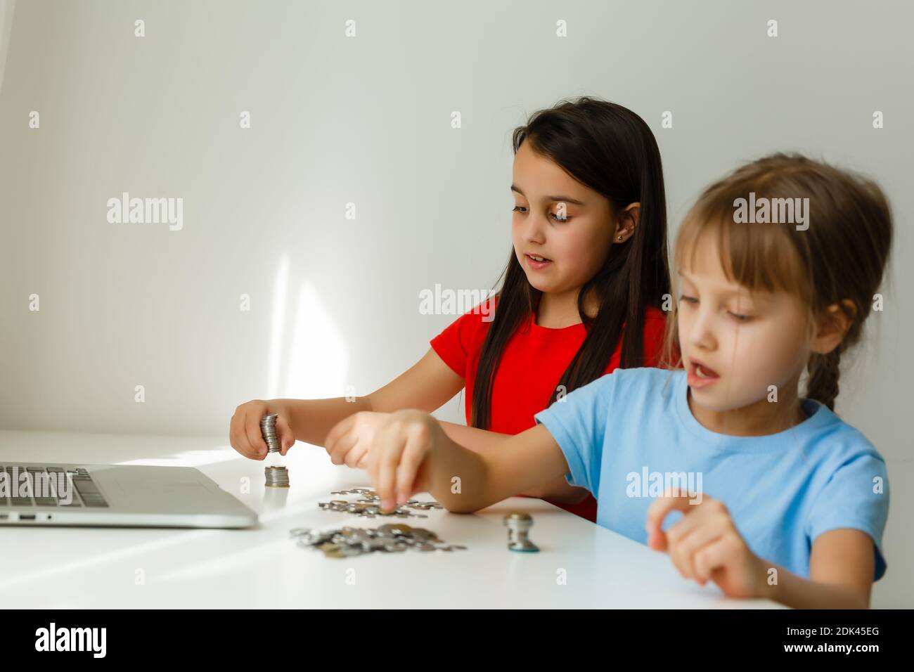 Two kids counting coins together Stock Photo - Alamy