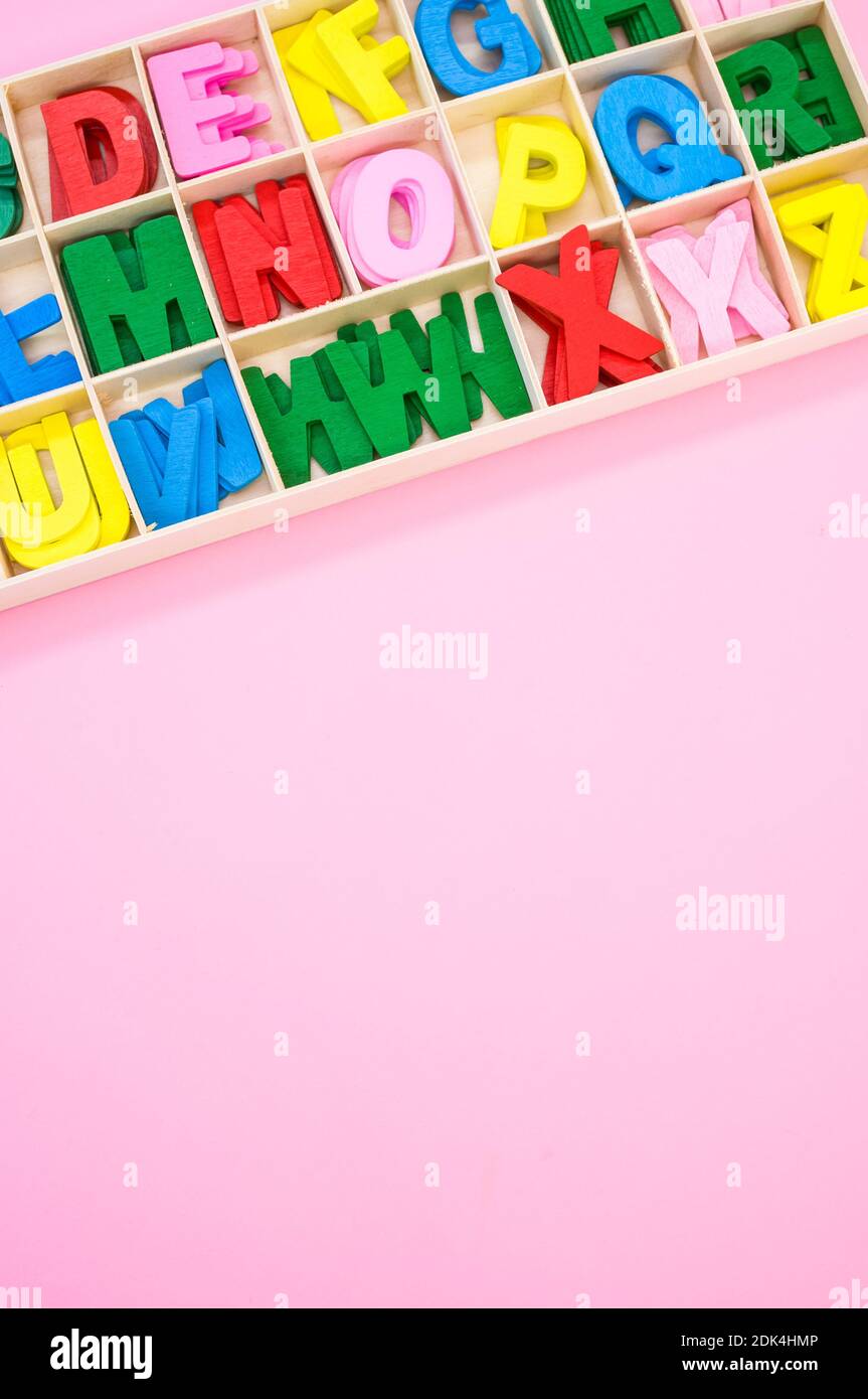 A vertical shot of colorful wooden letters in their case, placed on a ...