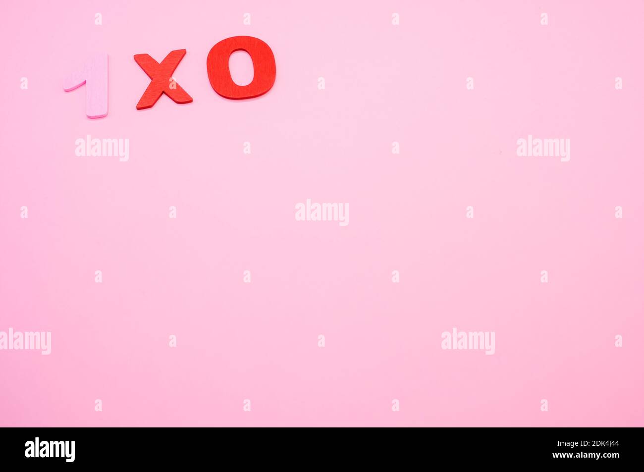 A top view of 1x0 written with wooden numbers on a pink surface Stock ...