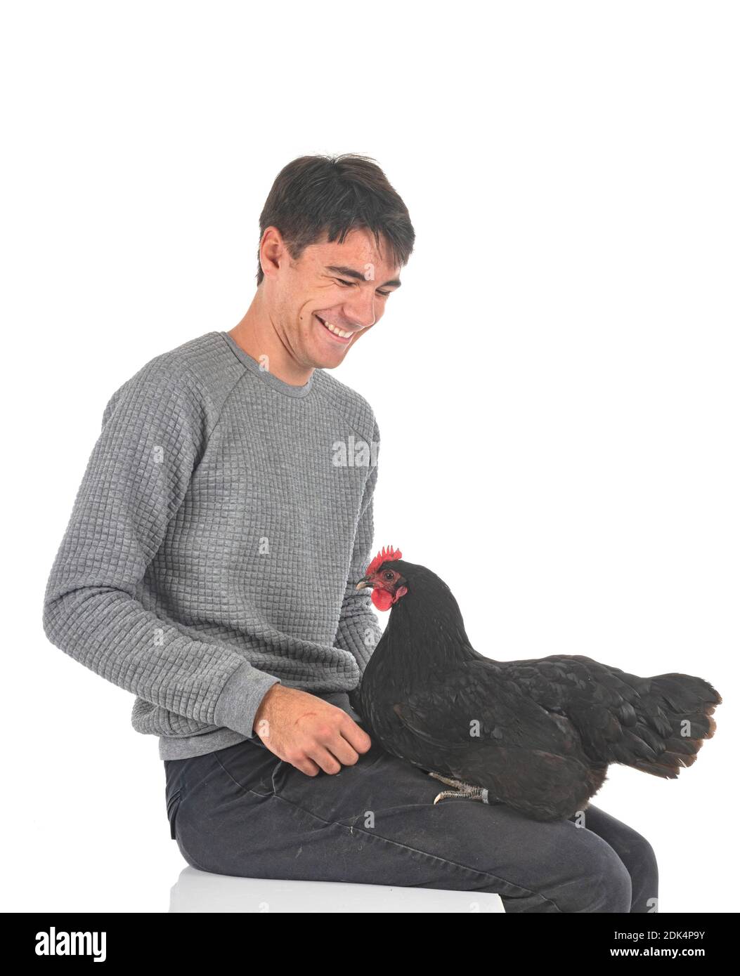young man and chicken in front of white background Stock Photo - Alamy