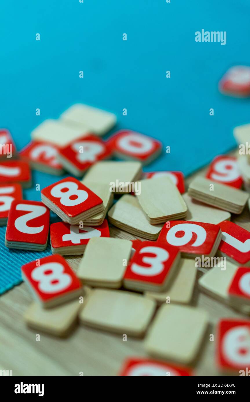 A verticalcloseup of a pile of tile numbers on a blue cloth Stock Photo ...