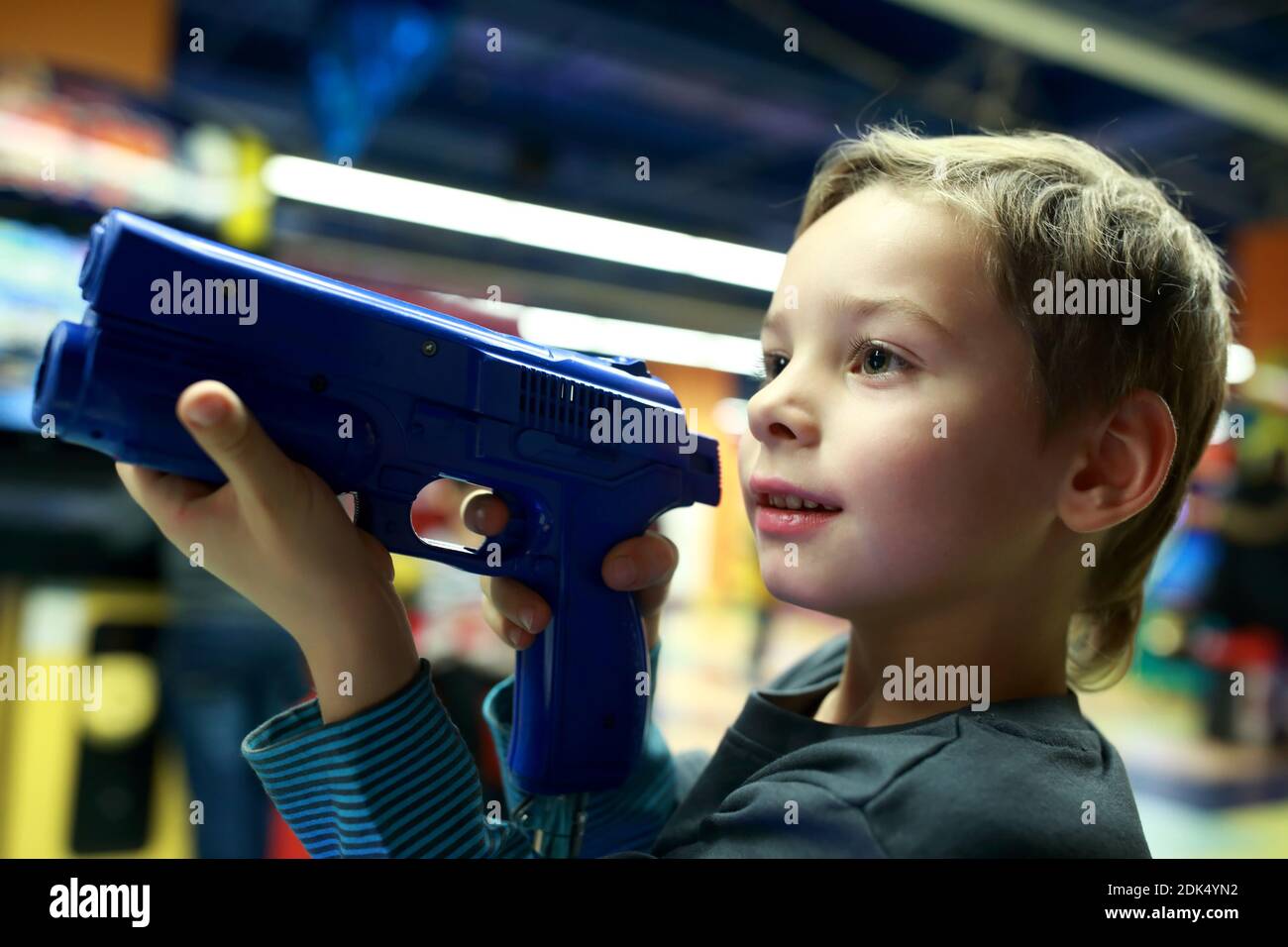 Boy is playing a shooter at indoor playground Stock Photo - Alamy