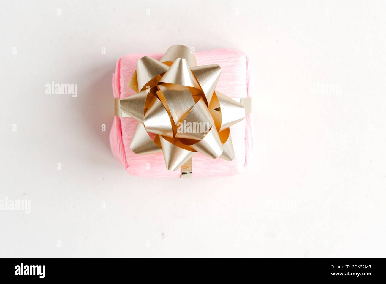 Gift box with golden bow on white background, top view Stock Photo - Alamy