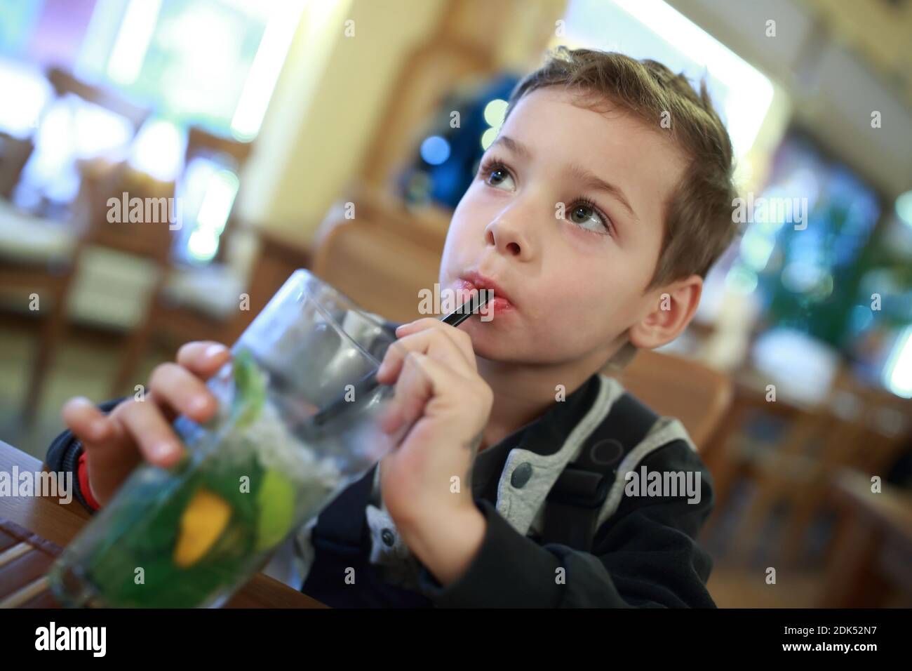 Boy drinking lemonade at table in cafe Stock Photo - Alamy
