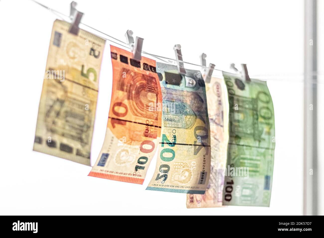 A paper Euro banknotes hangs on a rope with a clothespin on the ...