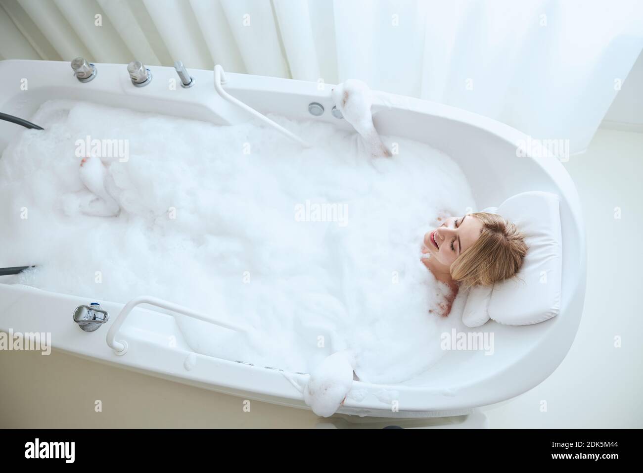 Pensive lady dreaming while resting in contemporary bathroom Stock ...