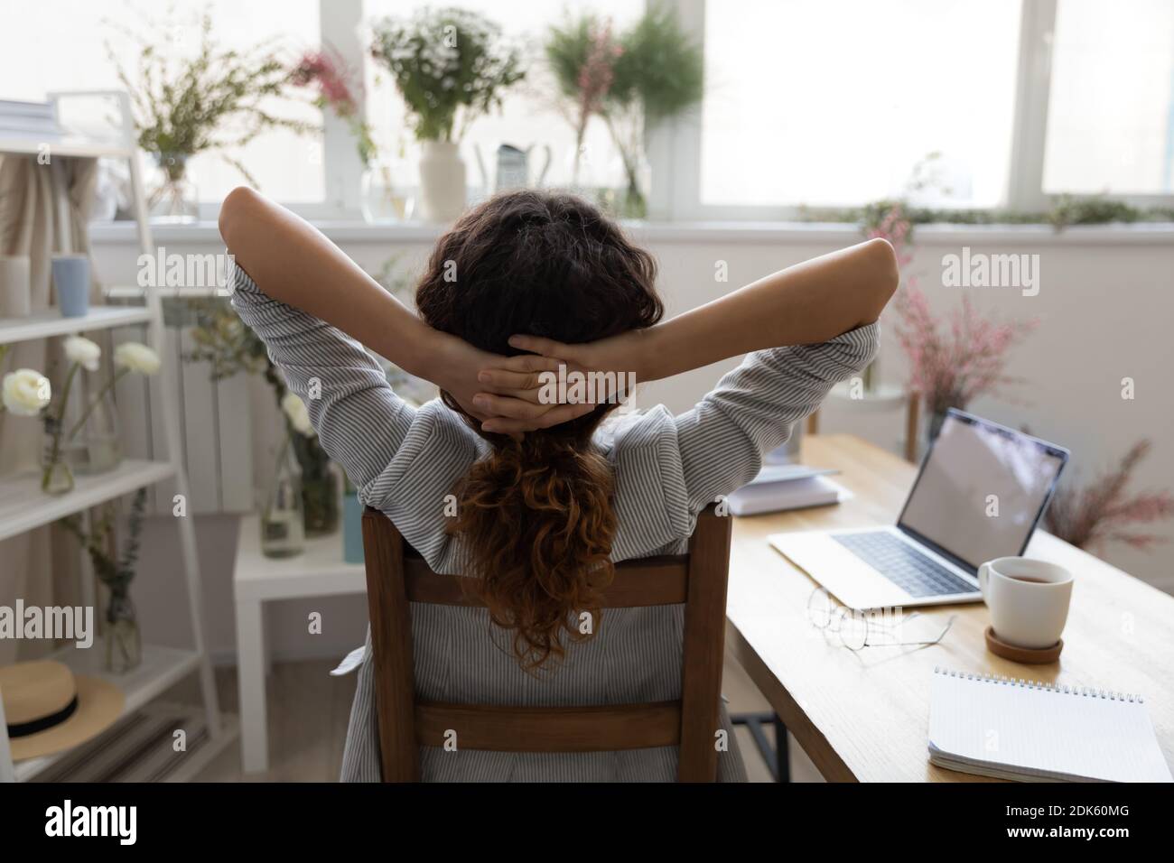 Back view of female designer resting on chair in studio Stock Photo - Alamy