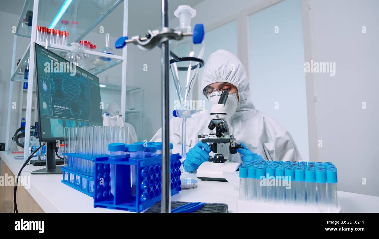 Scientist microbiology lab in protective suit conducting virus analysis ...
