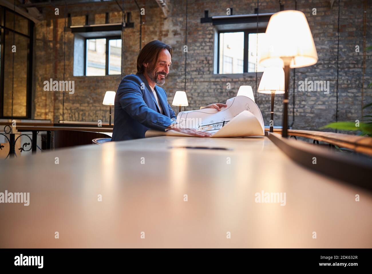 Hard-working man looking at some documentation at the desk Stock Photo ...