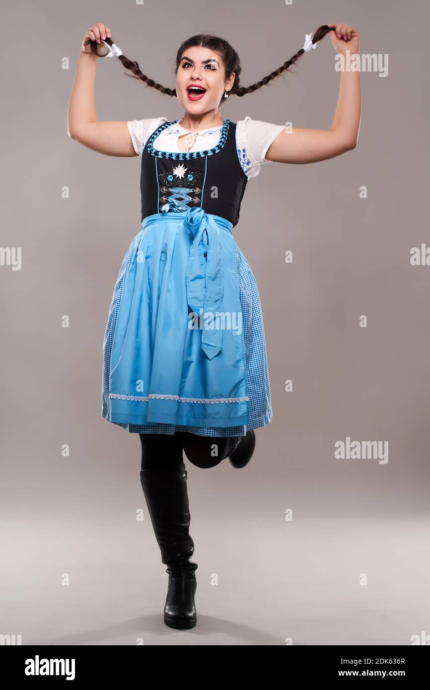 Young woman in traditional German folklore costume, isolated on gray ...