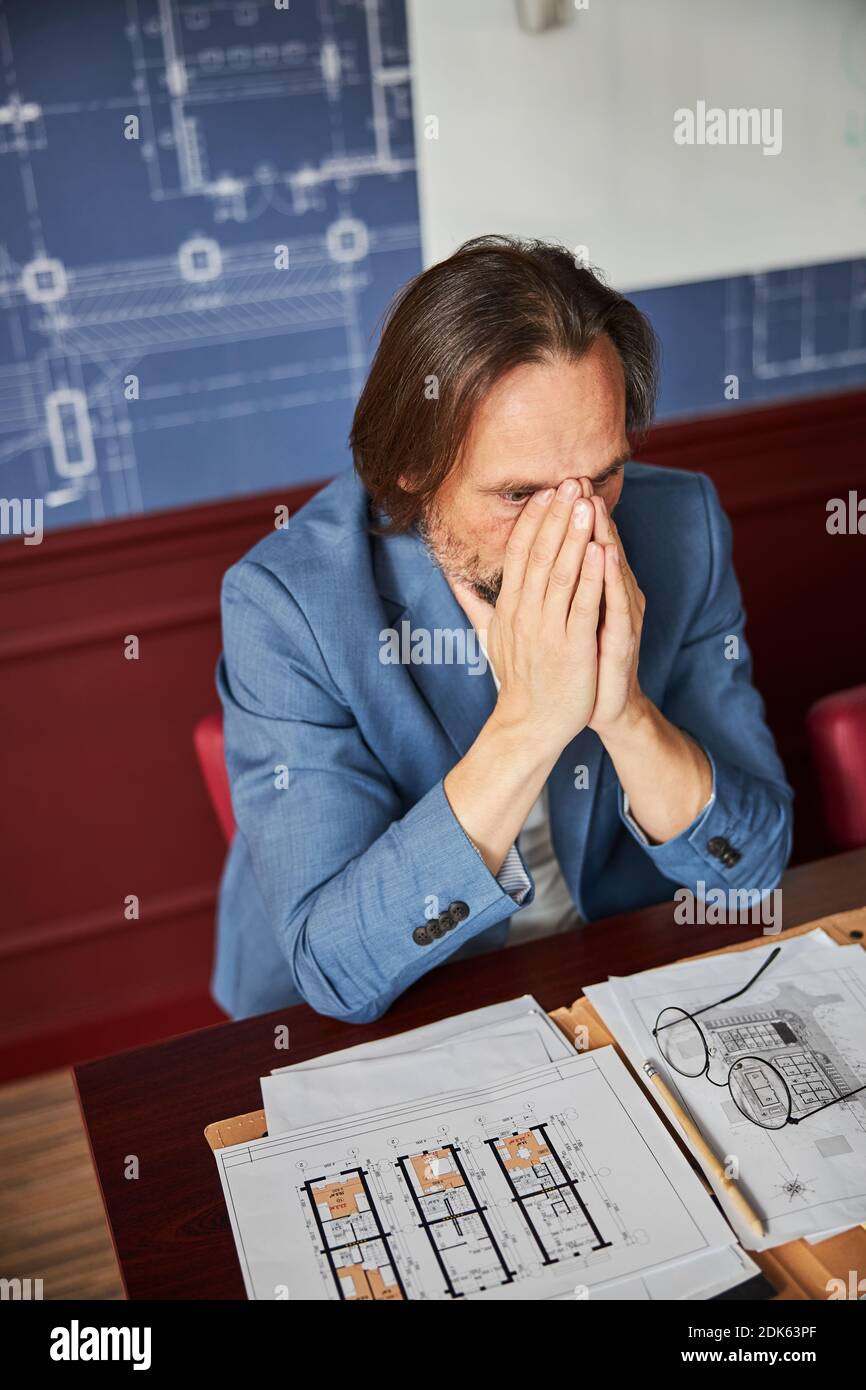 Distressed man experiencing fatigue and anxiety at work Stock Photo - Alamy