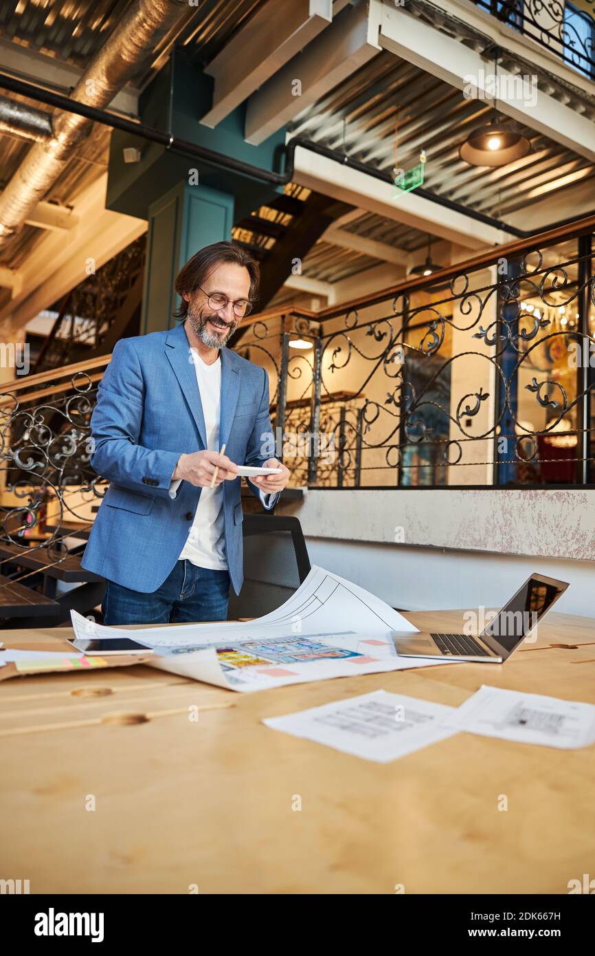 Contented man taking a photo of final work result Stock Photo - Alamy