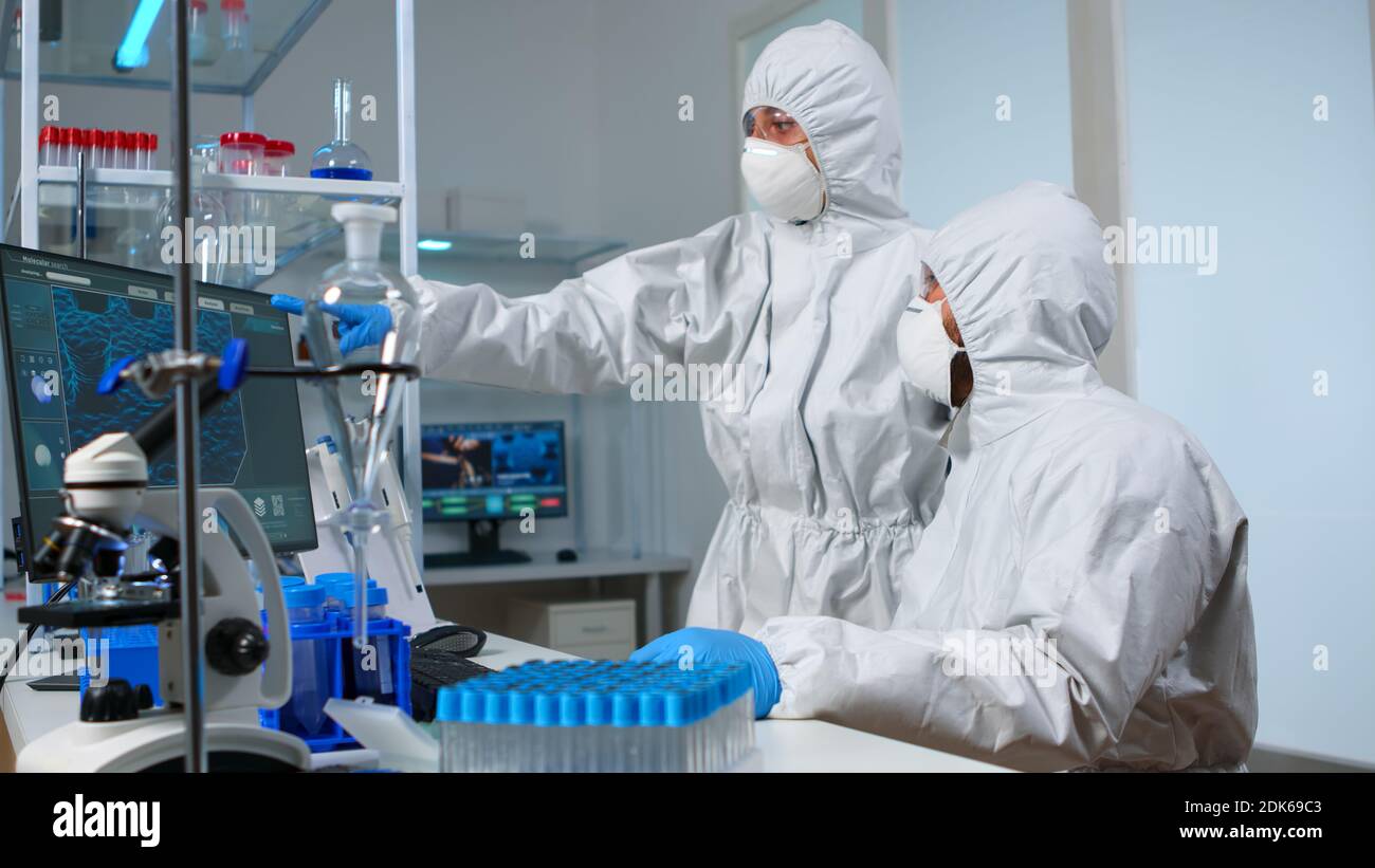 Scientist team in prorection suit arguing in front of pc looking at ...