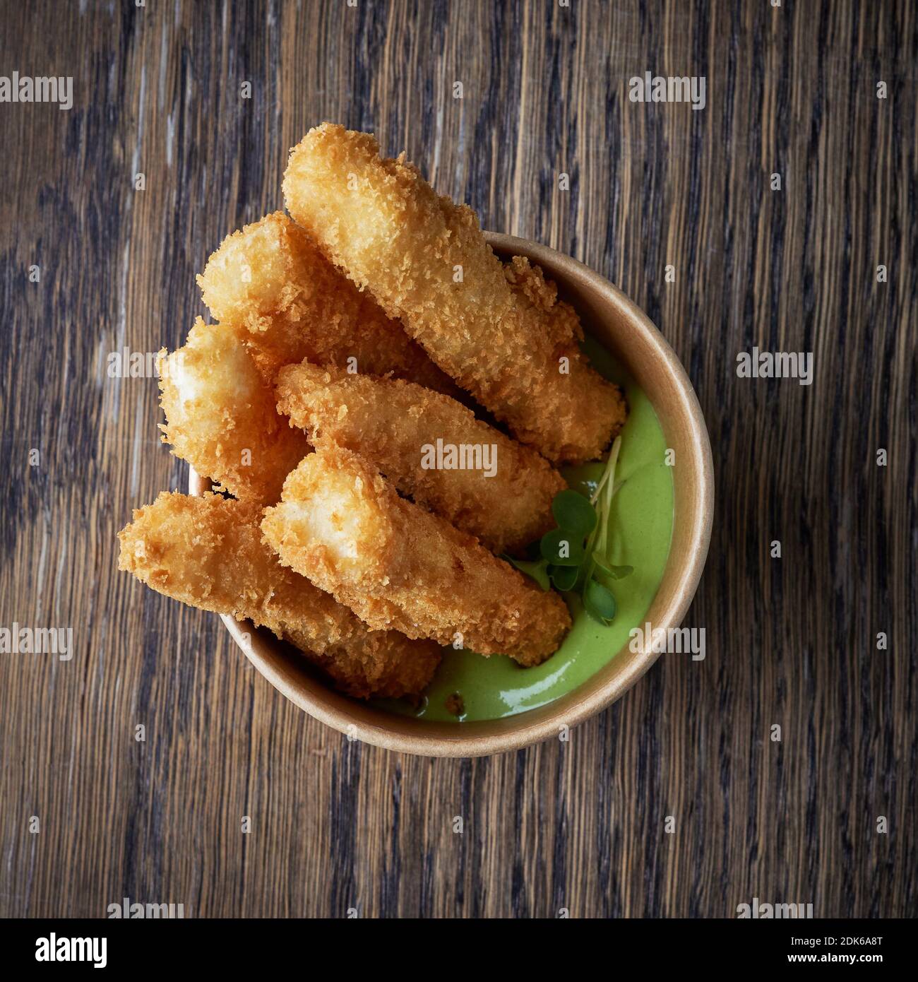 Breaded Mozzarella cheese snack in cardboard take away cup on wooden ...