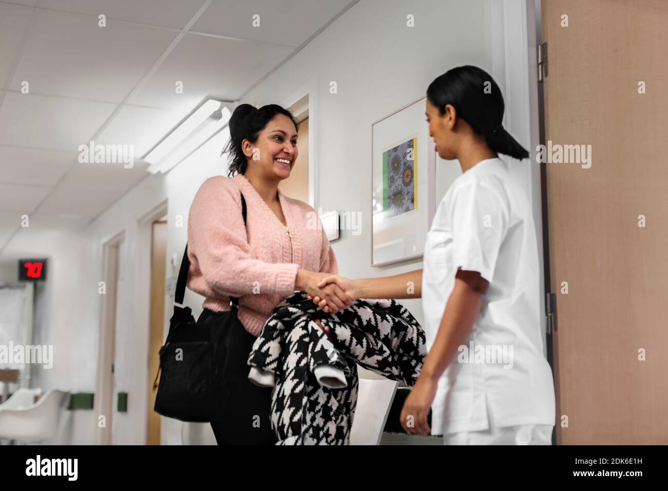 Doctor giving patient handshake Stock Photo - Alamy