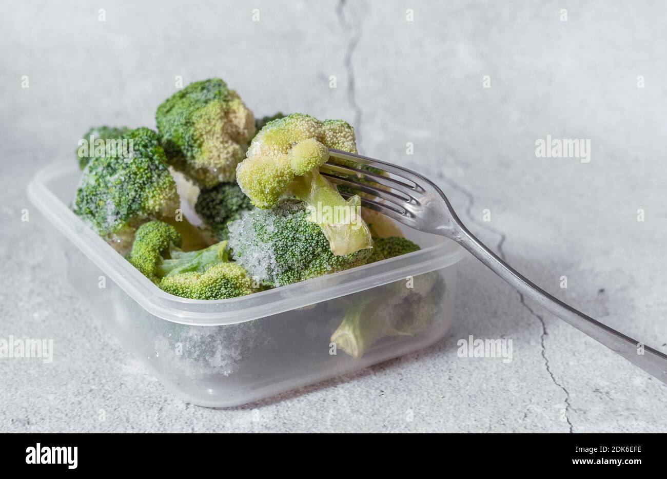 selective focus. frozen broccoli in a clear container. copyspace. light ...
